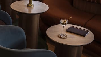 Um espaço aconchegante com uma mesa redonda, um copo de vinho e um caderno.