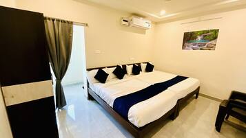 Quarto de hotel com cama, aparelho de ar condicionado e um quadro na parede.