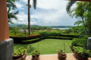 Jardim ajardinado com vista para a área costeira, incluindo uma praia e colinas.