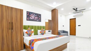 Quarto moderno com cama, guarda-roupa e área de estar.