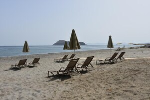 Na praia, barracas de praia (sobretaxa), espreguiçadeiras, guarda-sóis