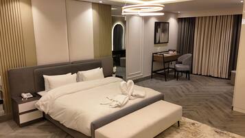 Quarto de hotel moderno com uma cama grande, uma escrivaninha e uma cadeira.