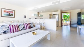 Uma sala de estar moderna com um sofá, mesa de centro e um quadro na parede.