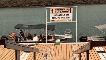 Um cais de madeira com um aviso sobre níveis variáveis da água.