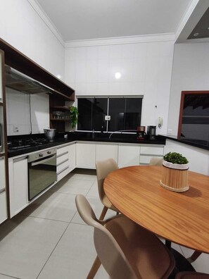 Um micro-ondas, um forno, uma placa de cozinha, utensílios de cozinha 