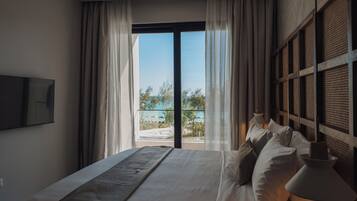 Quarto com cama, cortinas, vista para o exterior e televisão na parede.