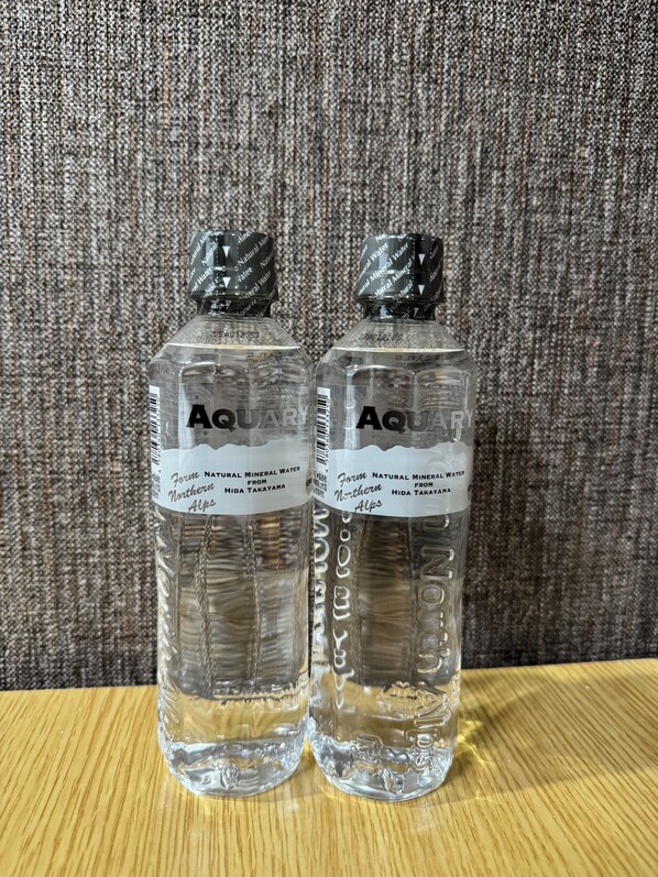 Duas garrafas de água Aquary sobre uma superfície de madeira.