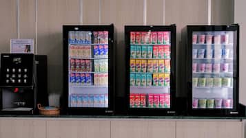 Três máquinas de venda automática com diversas opções de bebidas.