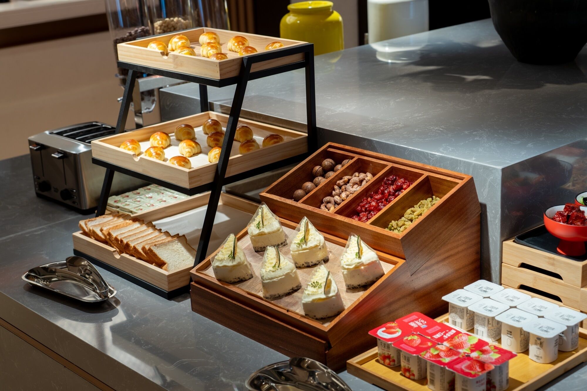 Buffet com diversos alimentos, incluindo doces, pães e produtos lácteos.