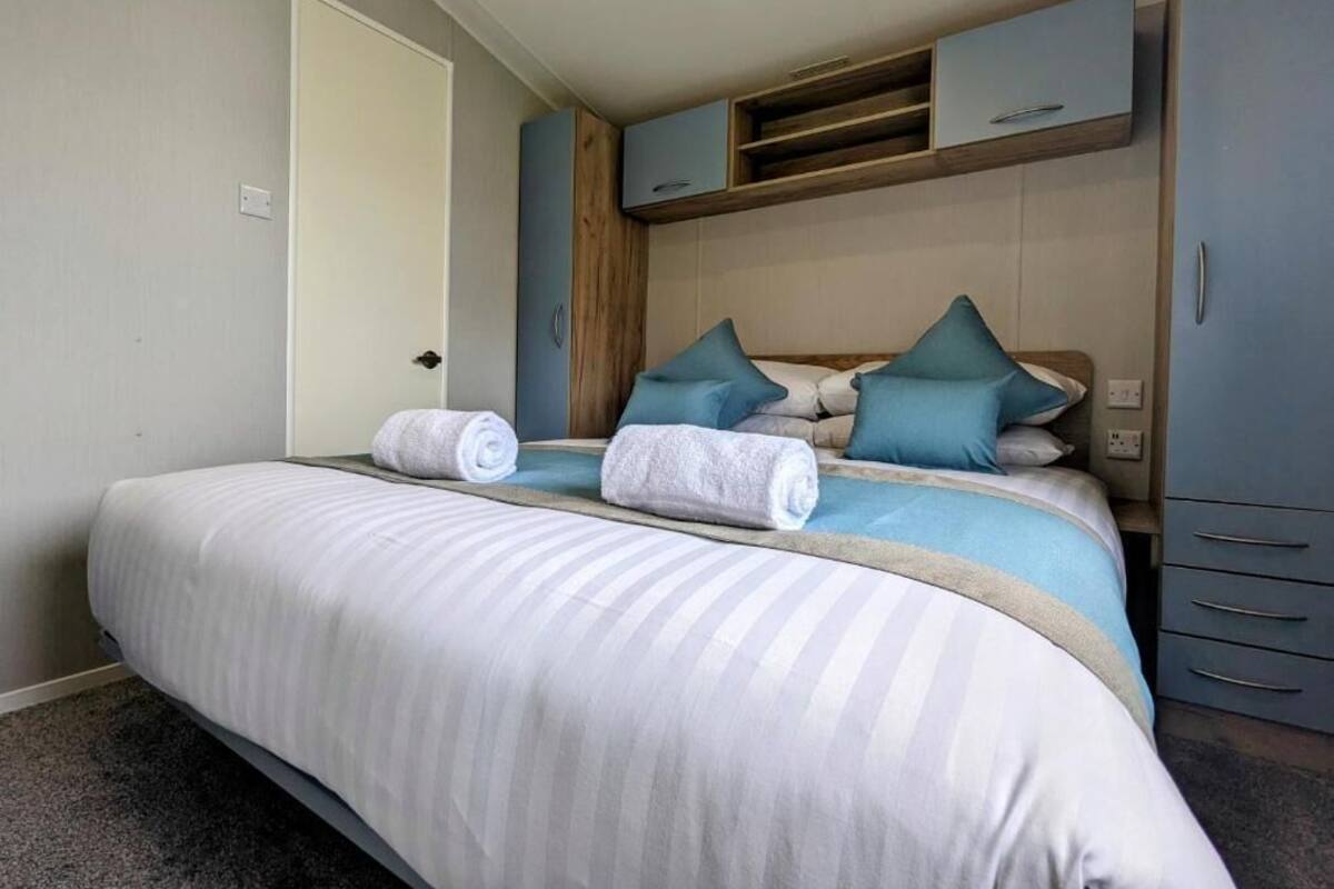 Quarto com uma cama grande, um guarda-roupa e uma porta.