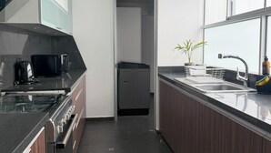 Uma cozinha moderna equipada com forno embutido, micro-ondas e máquina de lavar louça.