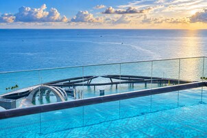 Uma piscina infinita com vista clara do oceano e uma estrutura em formato de ponte.