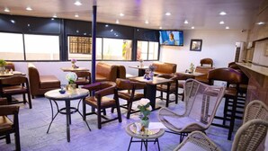 Um restaurante com várias áreas de estar, incluindo cabines e mesas, e uma televisão na parede.