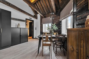 Uma área de refeições com cadeiras de madeira, uma mesa e um armário.