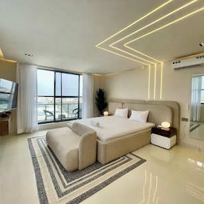 Quarto moderno com uma cama grande, televisão e vista para a varanda.