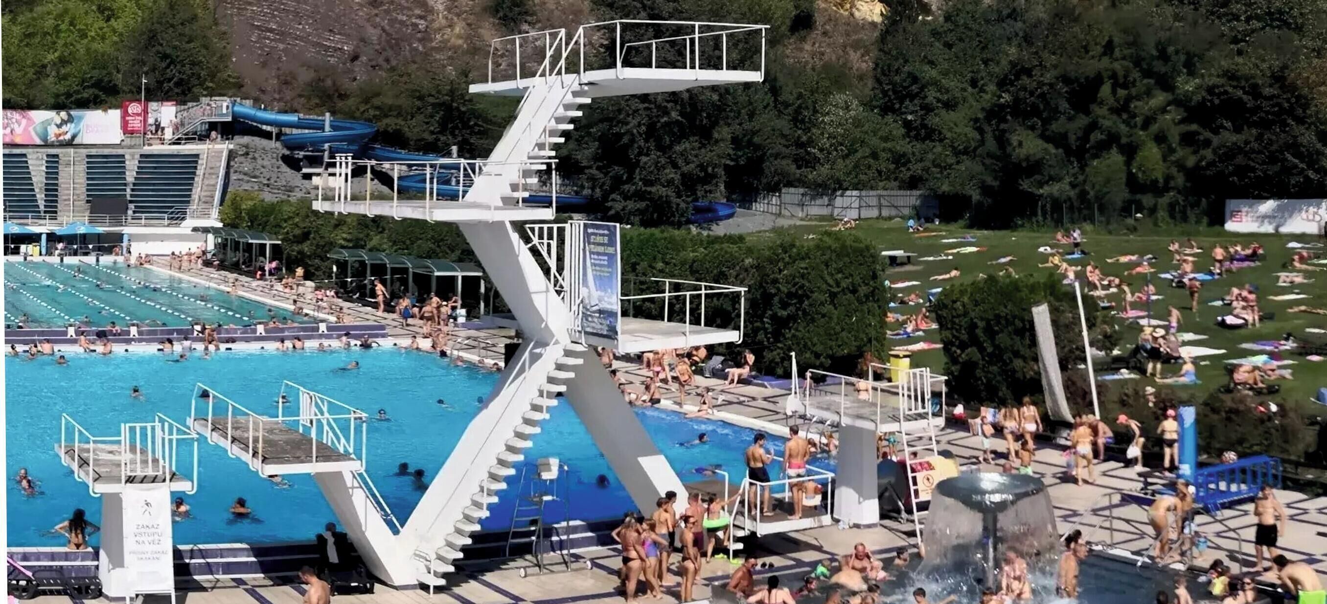 Uma piscina com plataforma de mergulho e várias pistas.