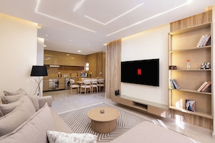 Apartamento luxo, 2 quartos, sacada, vista para a cidade | Ărea de estar | TV LED 65 polegadas com canais via satĂ©lite