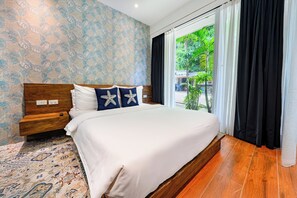 Cama bem arrumada com roupa de cama branca e almofadas com padrão de estrelas, cabeceira de madeira e tapete estampado.