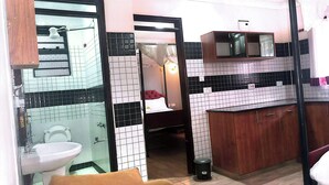 Casa de banho com sanita, lavatório e chuveiro.