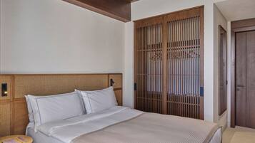 Quarto com cabeceira de madeira, cama com roupa de cama branca, ventilador de teto e guarda-roupa de madeira.