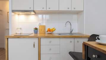 Um frigorífico, uma placa de cozinha, utensílios de cozinha