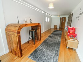 Um interior moderno com uma escrivaninha de madeira, uma cadeira preta, um tapete cinzento com padrão e um móvel de armazenamento vermelho.