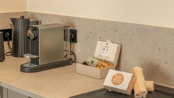 Uma cafeteira/bule, um frigorífico/congelador grande, um micro-ondas