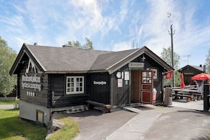 A wooden building with a reception area, labeled "Beitostolen hytter & camping," and a sign indicating "Reception."