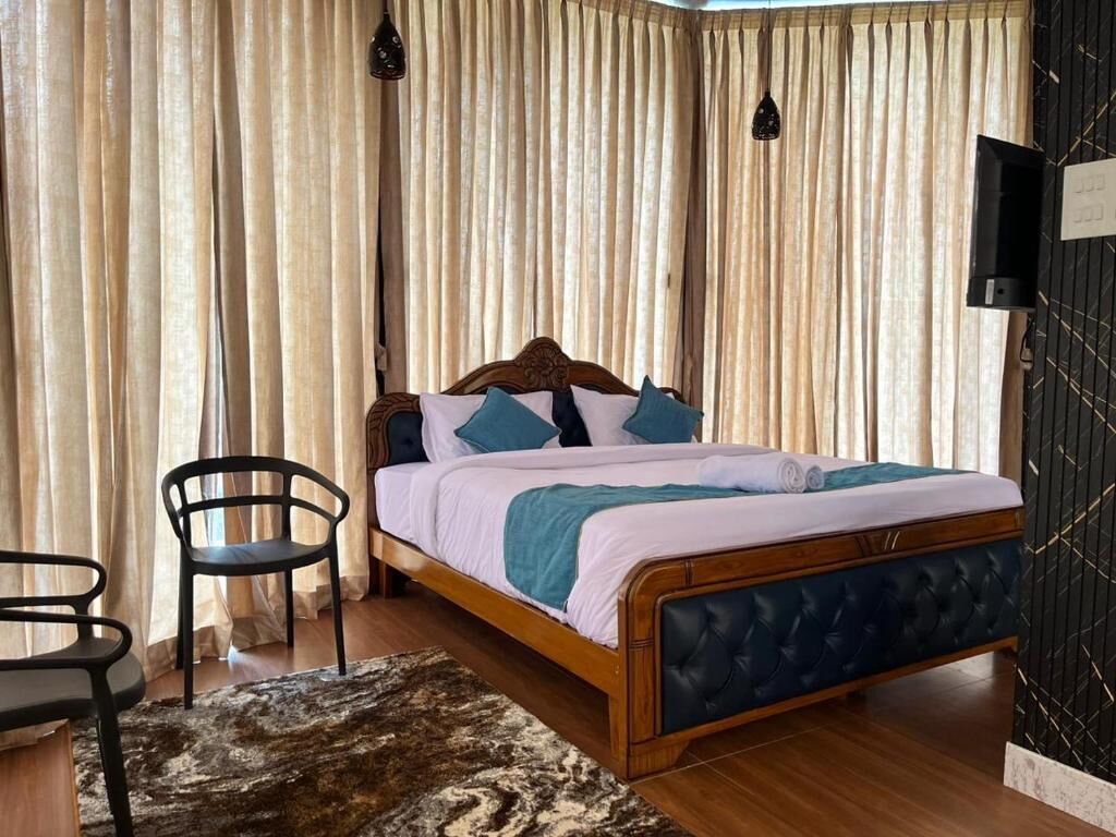 Um quarto com uma cama, uma cadeira e cortinas.