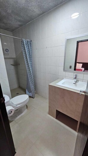 Quarto Duplo Básico | Casa de banho | Um polibã, toalhas fornecidas, sabão, champô