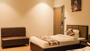 Quarto de hotel com uma cama, um sofá e um quadro na parede.