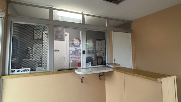 Quarto de canto com janela, um aviso de 'Não Fumar' e um sinal de 'Super' no chão.