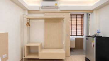 Quarto moderno e minimalista com uma cama beliche, um kitchenette e um guarda-roupa embutido.