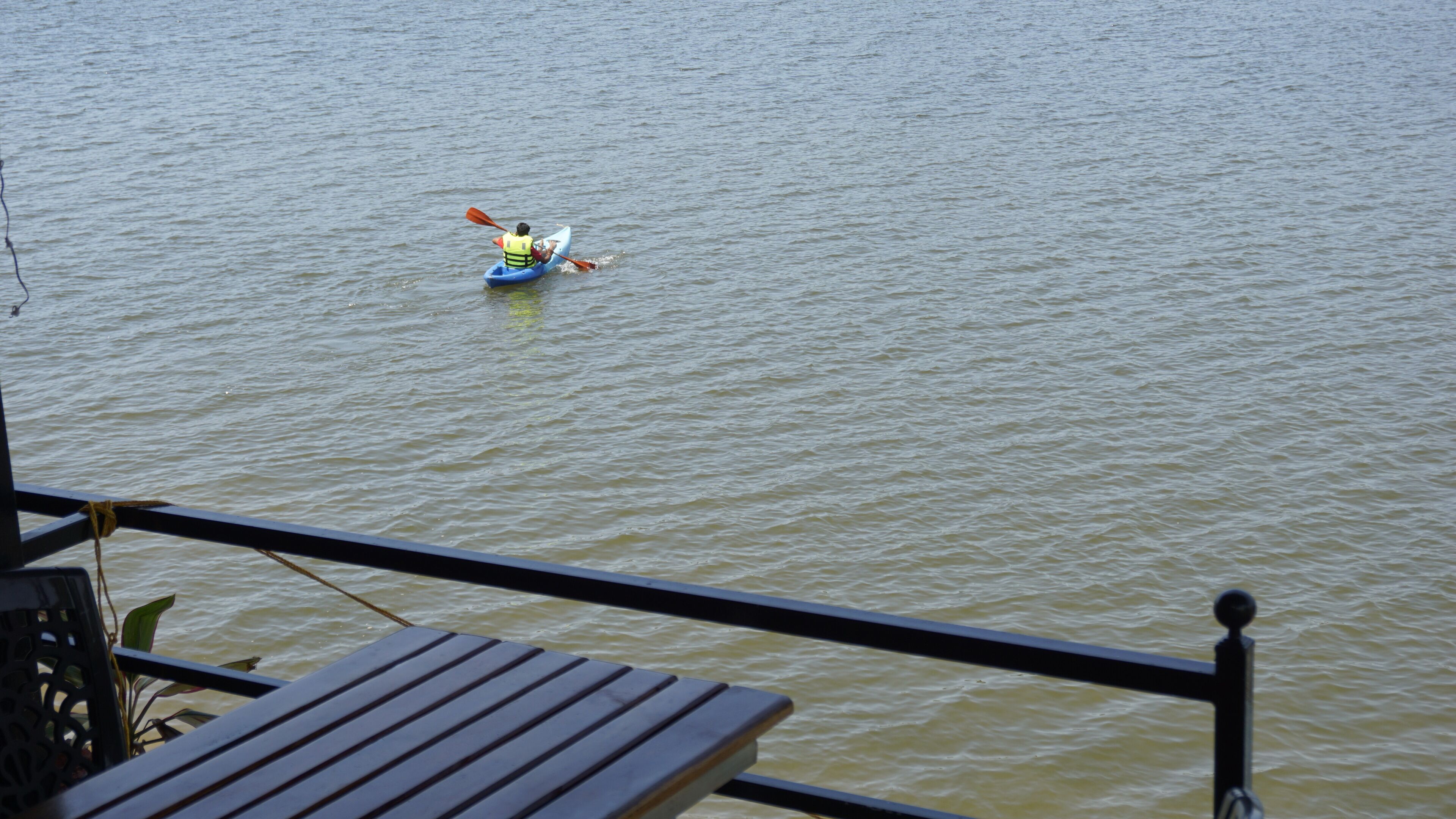Uma pessoa a remar num barco de caiaque em águas calmas.