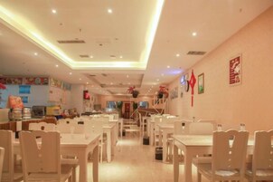 Restaurante com várias mesas, cadeiras, escada e teto com iluminação embutida.