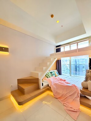 Quarto moderno com beliche, escada embutida e uma grande janela com vista para a cidade.