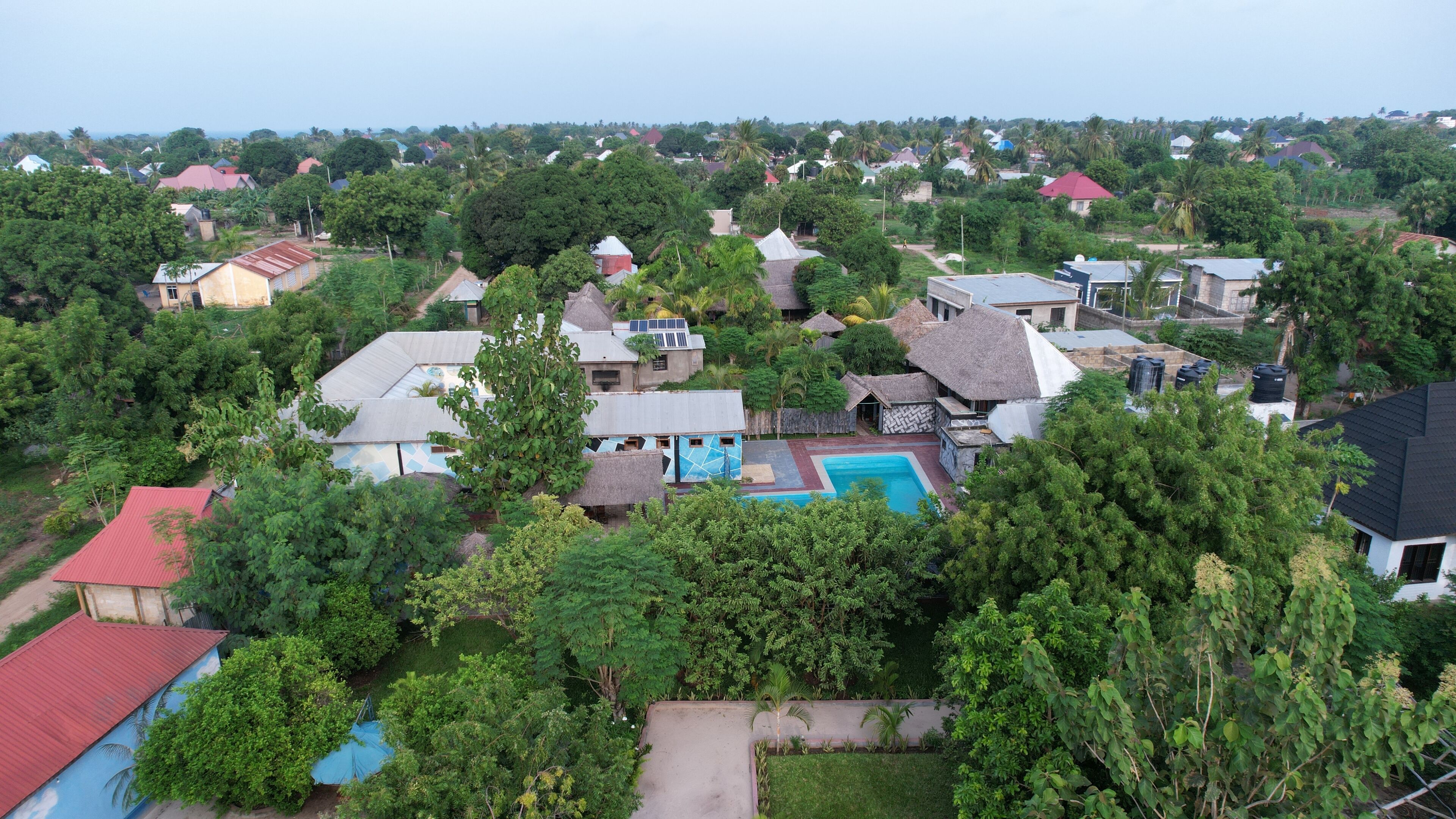 Uma área residencial com casas, piscina e vegetação exuberante.