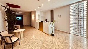 Uma área de recepção moderna com balcão, assentos e uma parede decorativa.