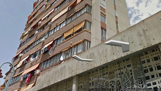 Um edifício alto, com vários andares e design arquitetônico moderno, com varandas e grandes janelas.