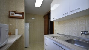 Uma cozinha com geladeira, pia e armários.