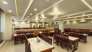 Um restaurante amplo com várias áreas de estar, incluindo cabines e mesas.