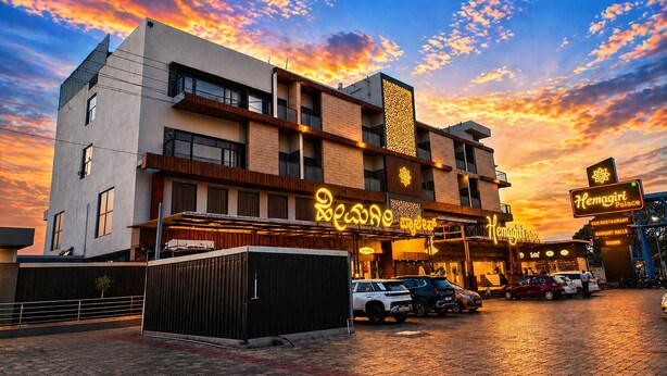 Um hotel com fachada moderna, uma placa indicando Palácio Hemagiri e uma área de entrada pavimentada.
