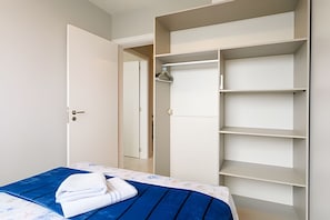 Quarto com cama, guarda-roupa e porta.