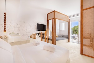 Quarto de hotel moderno com uma cama grande, televisão, varanda e vista para o exterior.