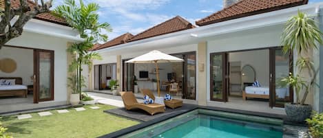 Uma villa moderna com piscina, área de estar ao ar livre e um jardim bem cuidado.
