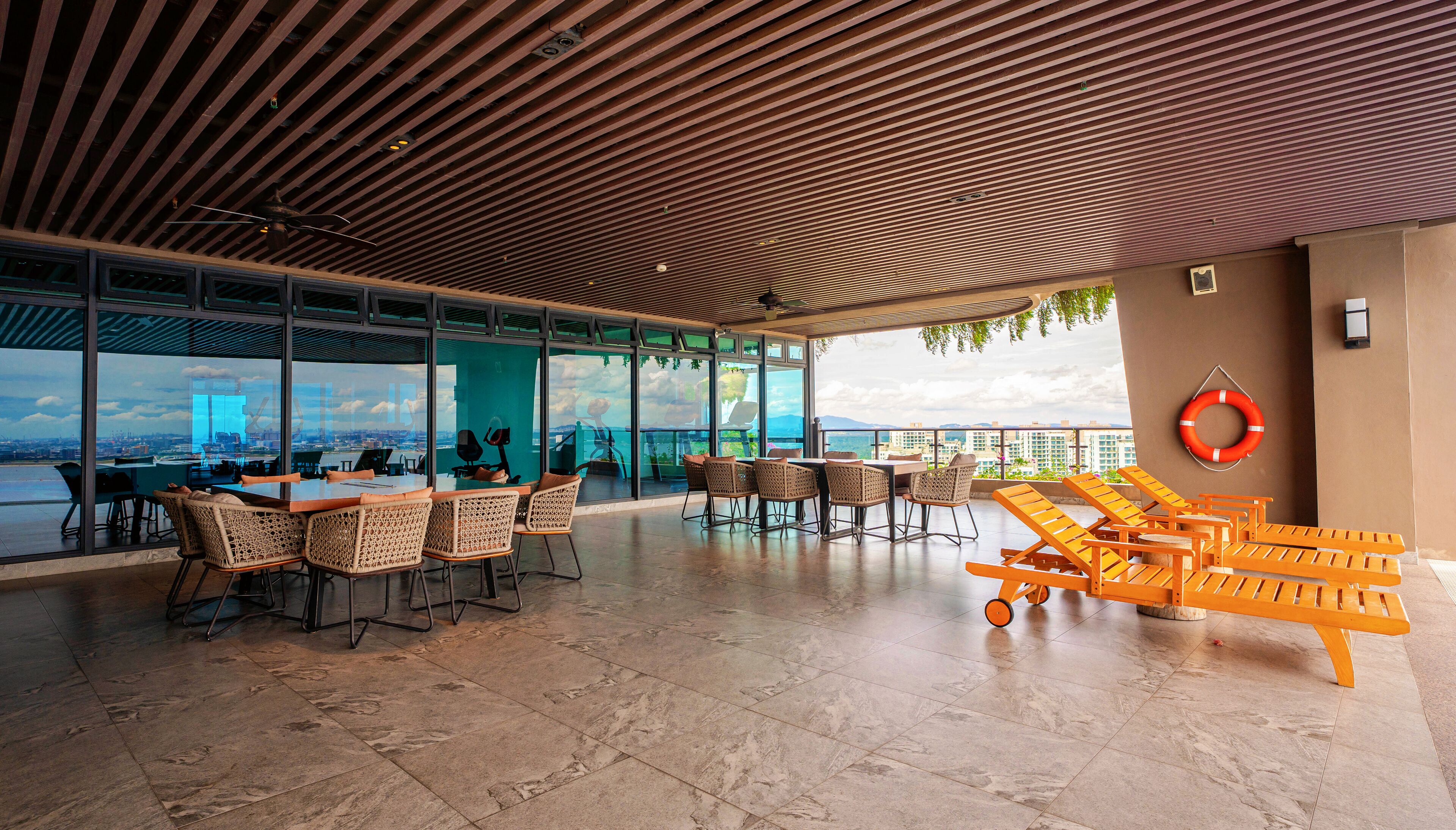 Um espaço amplo e arejado, com pé direito alto, grandes janelas e vista para o horizonte urbano.