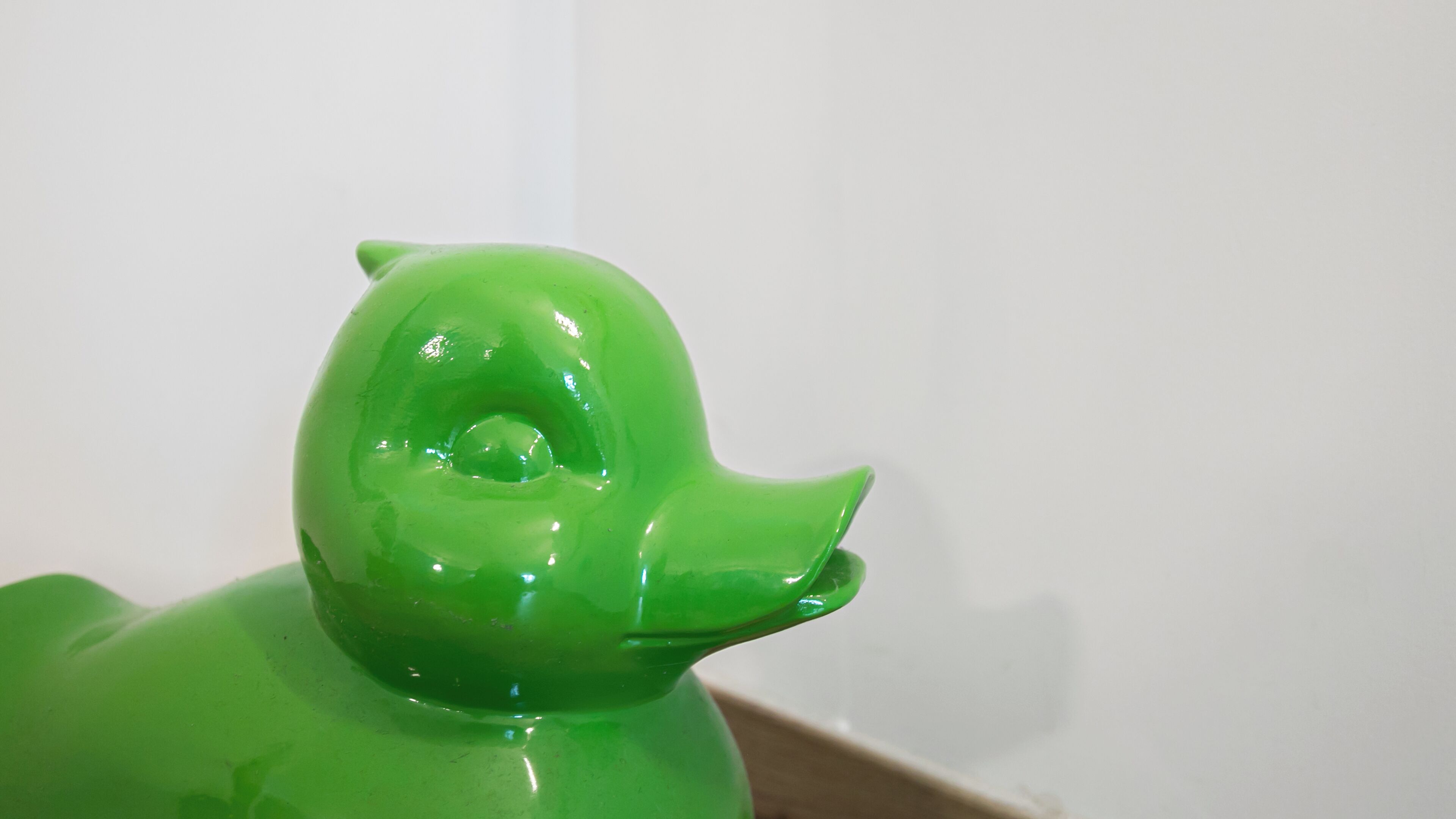 Uma pequena estatueta de pássaro verde feita de cerâmica.