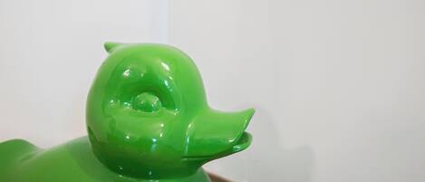 Uma pequena estatueta de pássaro verde feita de cerâmica.