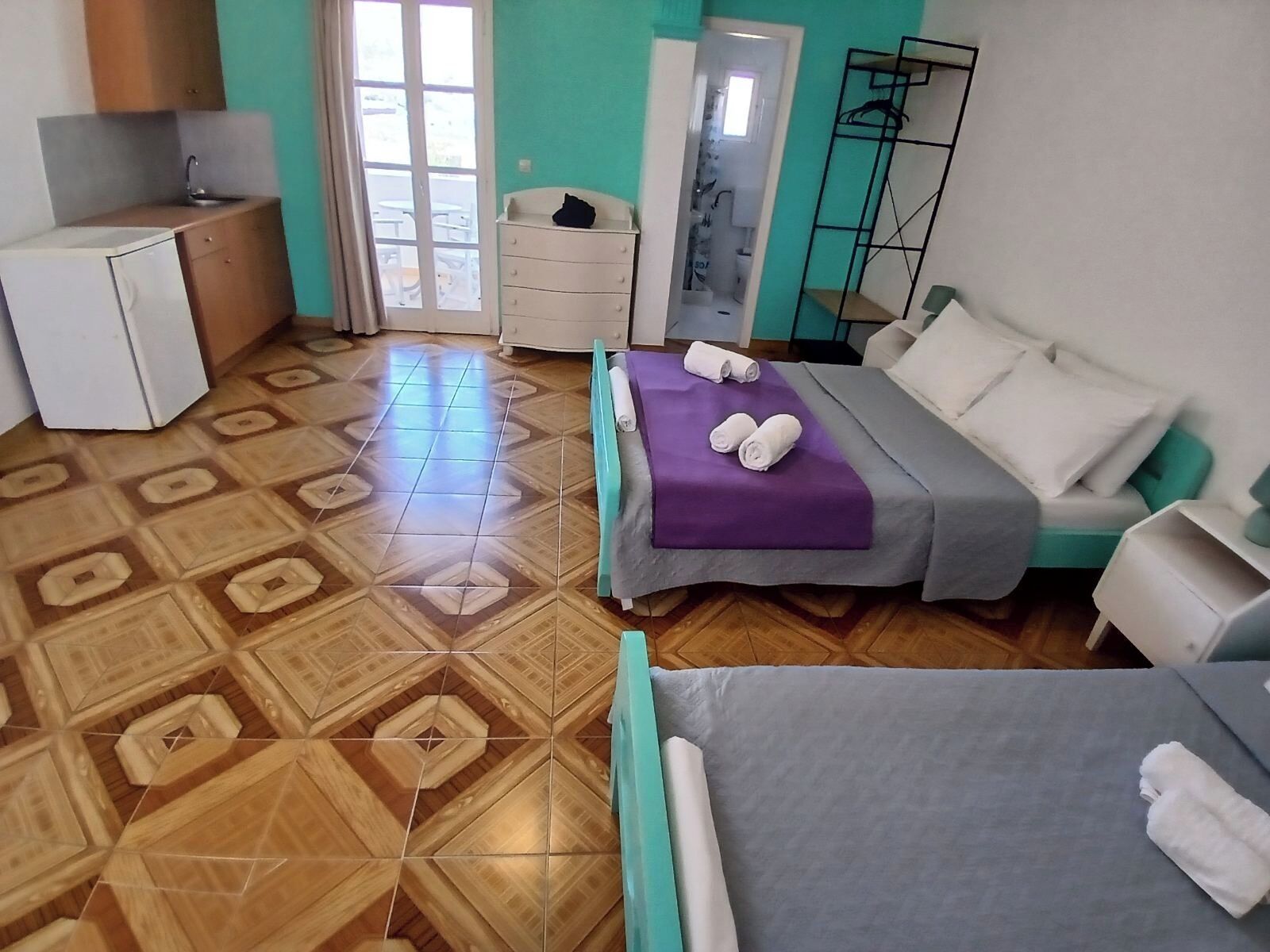 Quarto com cama, escrivaninha, cadeira, guarda-roupa e banheiro.