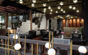 Interior de restaurante com mesas, cadeiras e um espaço de bar.